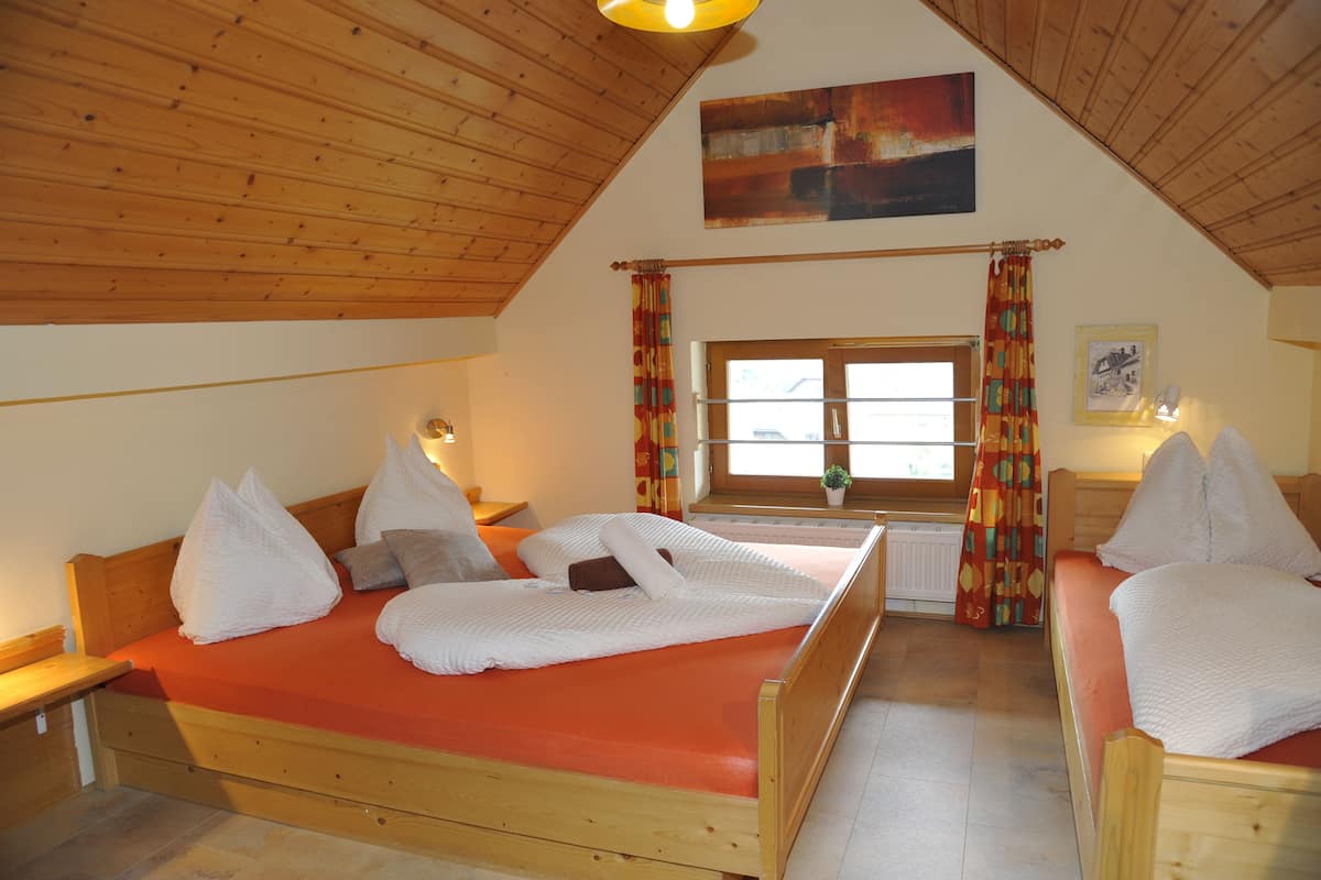 Um quarto com painéis de madeira, uma cama, uma janela e um quadro na parede.