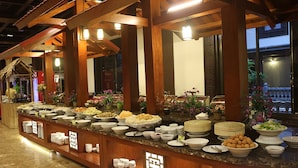 Buffet com diversos pratos e decoração arquitetônica tradicional asiática.