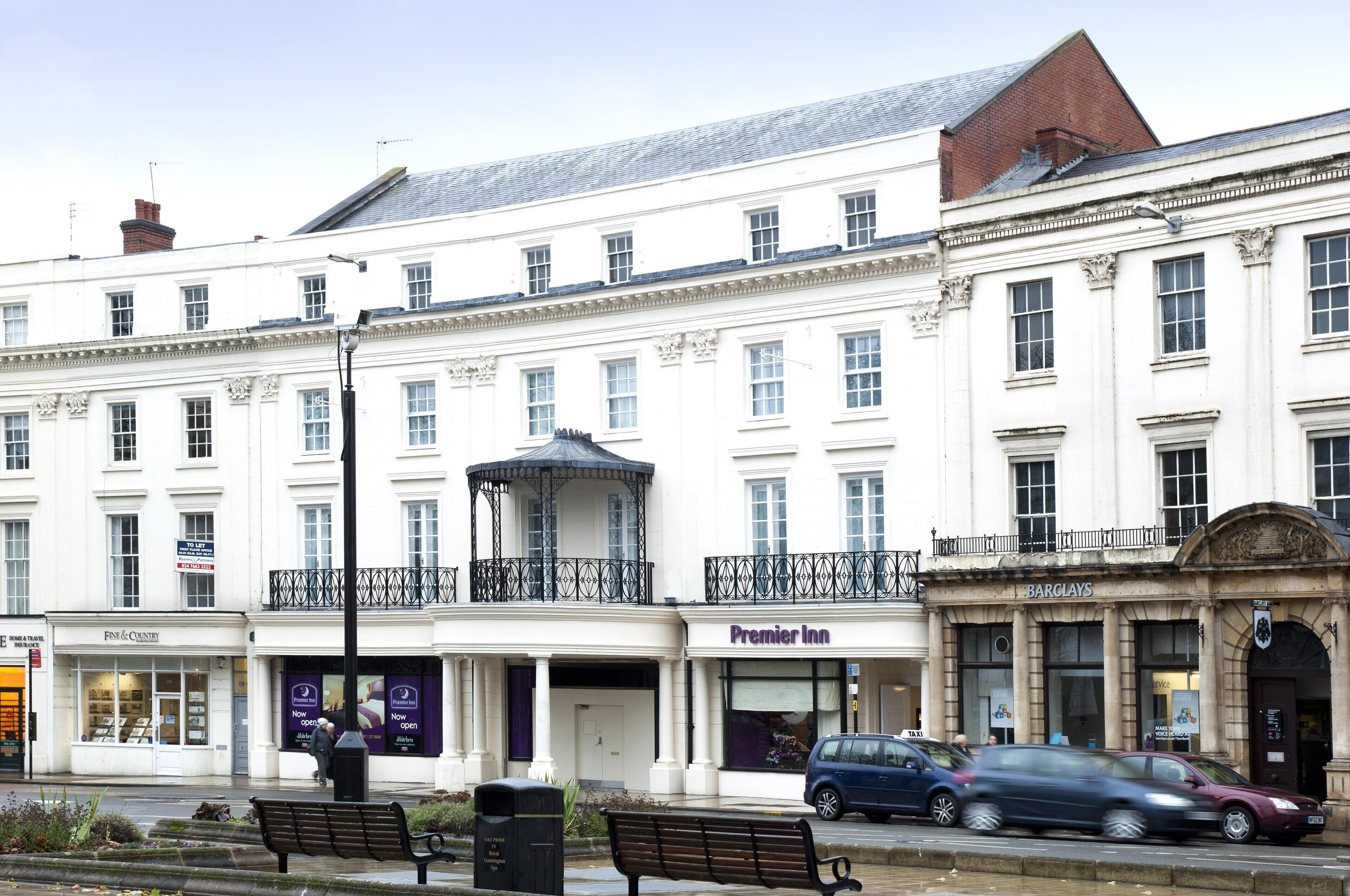 Um edifício de vários andares com uma entrada destacada identificada como 'Premier Inn'.