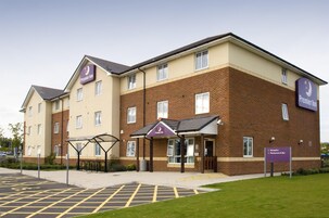 Um hotel Premier Inn com fachada de tijolos, entrada coberta e área de estacionamento.