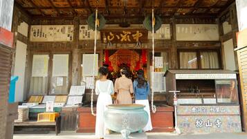 Um santuário japonês tradicional com vigas de madeira e decorações penduradas.