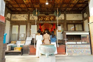 Um santuário japonês tradicional com vigas de madeira e decorações penduradas.