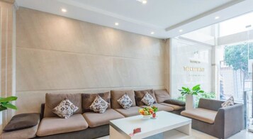 Uma sala de estar moderna com um conjunto de sofás, uma mesa de centro e uma janela grande com vista para a cidade.