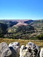 Vista panorâmica de um vale com uma cidade e um castelo no topo de uma colina.
