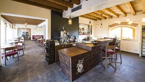 Espaçosa área de bar com vigas de madeira, balcão central e diferentes opções de assento.
