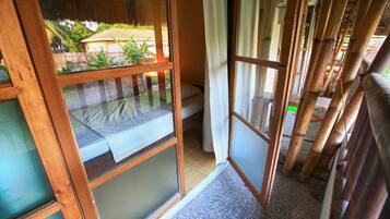 Um quarto com uma cama, uma janela e uma porta.