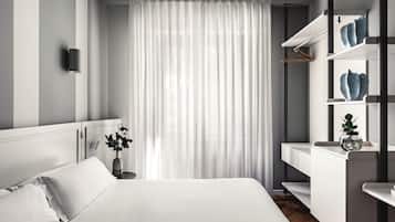 Quarto moderno com uma cama grande, uma mesa de cabeceira com um vaso, um guarda-roupa com prateleiras e uma janela com cortinas leves.
