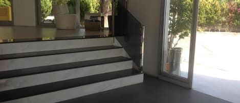 Uma escadaria moderna com porta de vidro que dá para uma área externa.