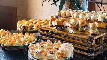 Uma mesa de buffet com diversos pães e sanduíches.