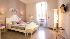 Quarto com cama, mesa de cabeceira, abajur e cômoda.