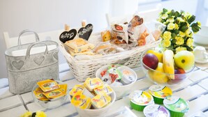 Um buffet de café da manhã com diversas opções de alimentos, incluindo frutas, doces e iogurte.