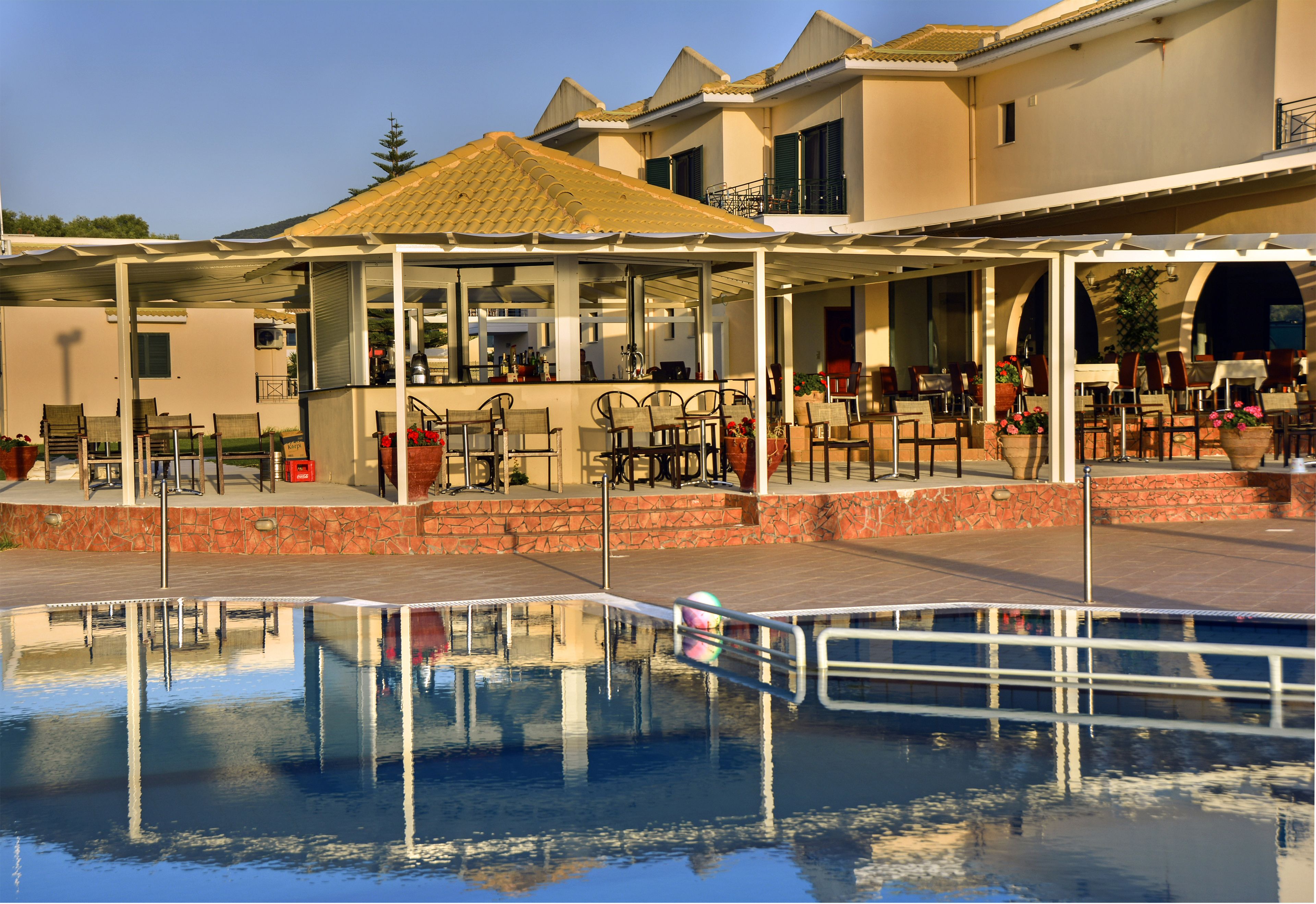 Uma área de piscina com varanda coberta, mobiliário de exterior e piscina refletora.