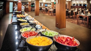 Buffet com diversas opções de comida, incluindo saladas, vegetais e carnes.