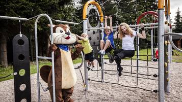 Um parquinho com um personagem temático de macaco e diversas estruturas de recreação.