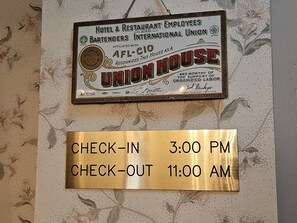 Placa de hotel com horário de check-in às 15:00 e check-out às 11:00.