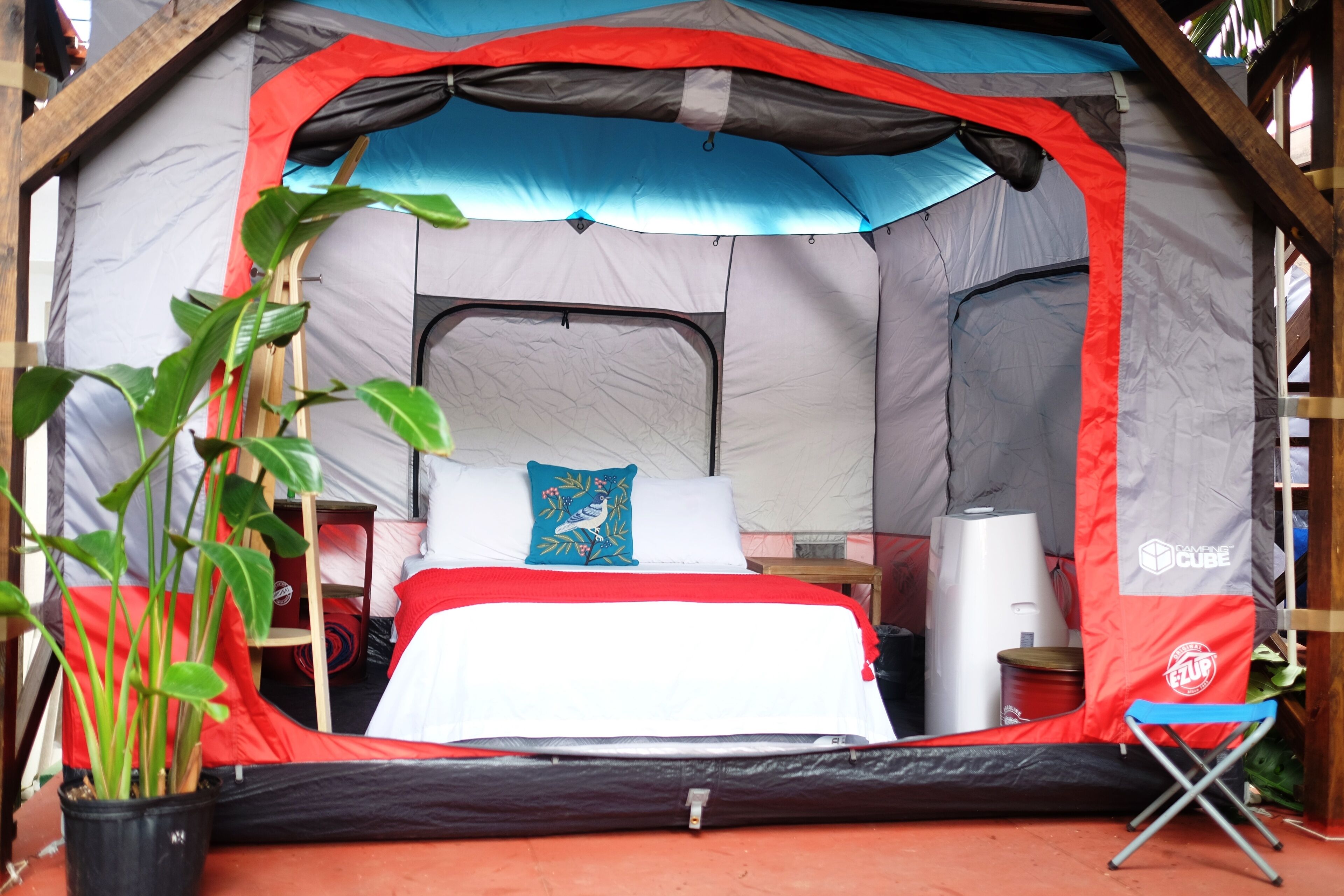 Uma tenda com uma cama, uma mesa pequena e uma cadeira.