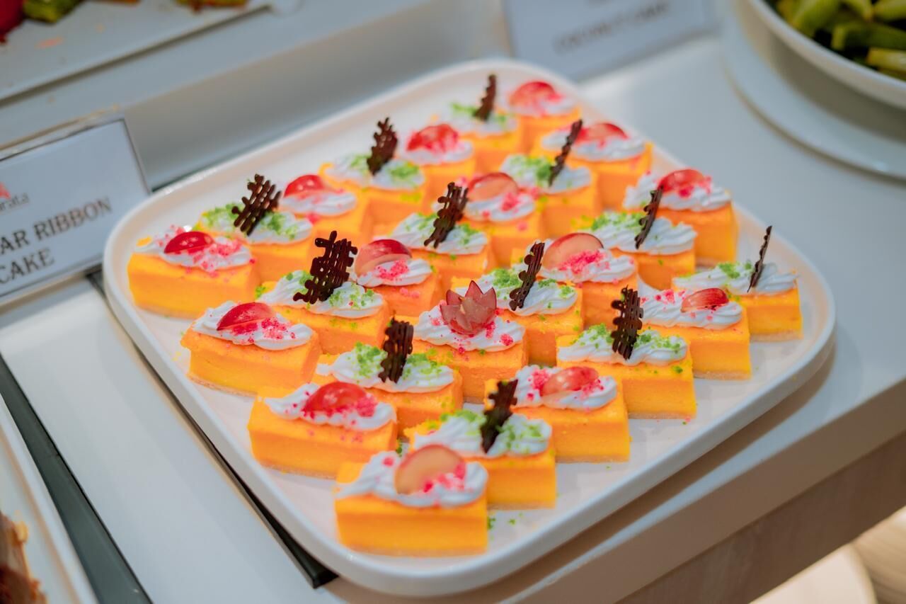 Uma bandeja de sobremesas quadradas com chantilly e guarnições decorativas.