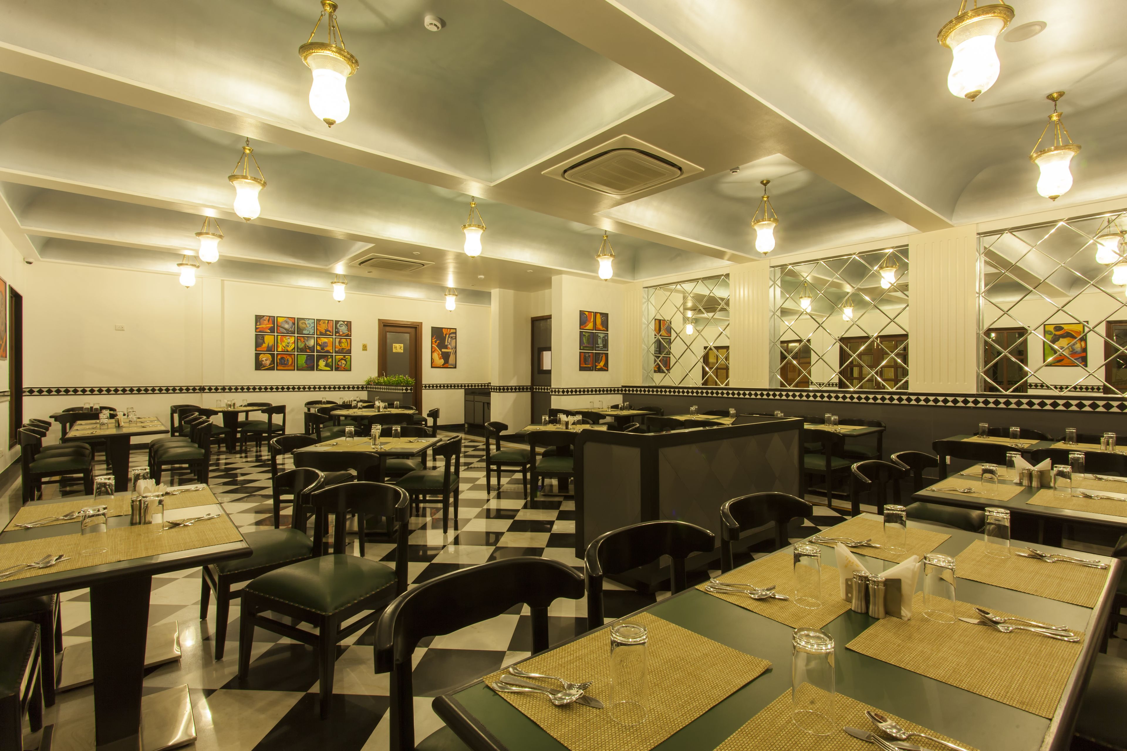 Um restaurante com chão xadrez, várias mesas e cadeiras.