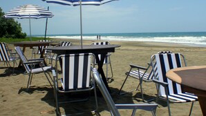 Na praia, espreguiçadeiras, guarda-sóis de praia, toalhas de praia