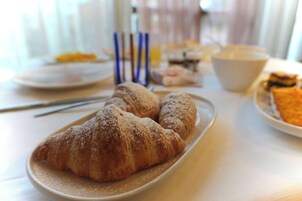 Uma mesa com croissants e uma tigela de sopa.