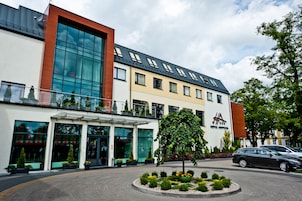 Um hotel com design moderno, com grandes janelas e um jardim bem cuidado.