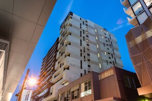 Um edifício alto com vários andares, janelas amplas e design arquitetônico moderno.