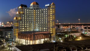 Um hotel grande e com vários andares, com um design arquitetônico marcante, incluindo uma cúpula central e várias torres.