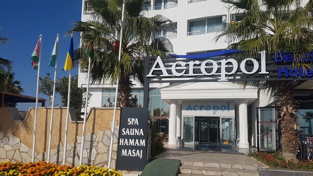 Entrada de um hotel com um letreiro indicando 'Acropol Hotel' e 'SPA SAUNA HAMAM MASAJ'.