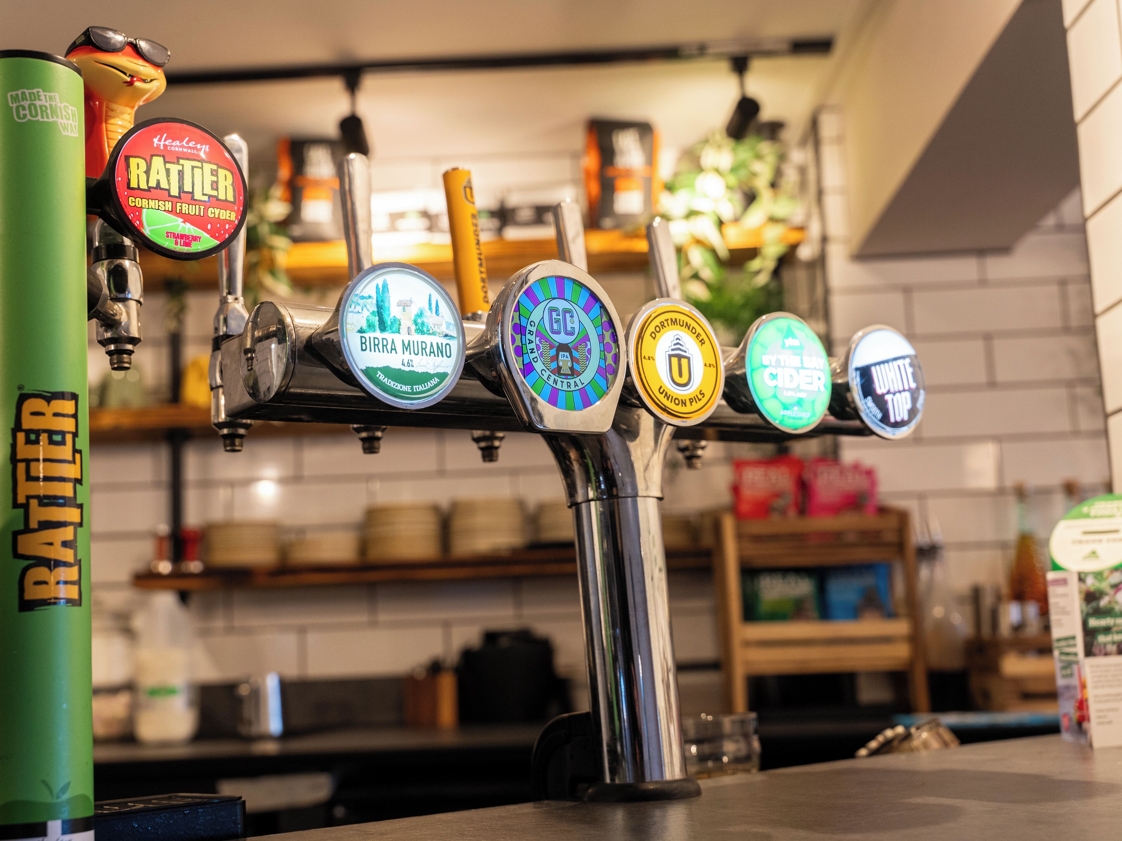 Um sistema de torneiras com diversas etiquetas de cerveja, incluindo marcas como Rattler e Birra Murano.