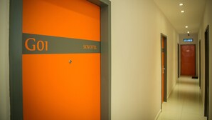 Corredor com porta laranja identificada com a placa 'G01 SOVOTEL'.