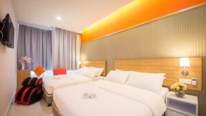 Quarto de hotel com duas camas, uma TV, uma poltrona de massagem e uma mesinha com um vaso de flores.
