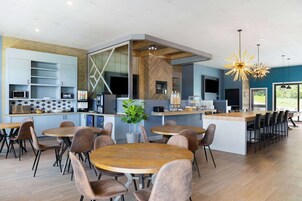 Uma cozinha moderna com eletrodomésticos embutidos, uma ilha central com assentos e uma janela grande que oferece muita luz natural.