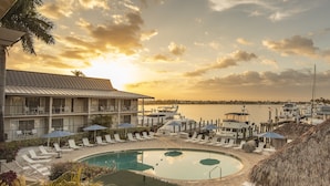 Resort com piscina, espreguiçadeiras e vista para o porto de iates.