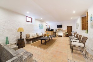 Uma sala de estar aconchegante com sofá, mesa de centro de madeira e cadeiras de vime.