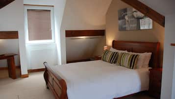 Quarto com cama de madeira, mesa de cabeceira, janela com persianas e uma obra de arte na parede.