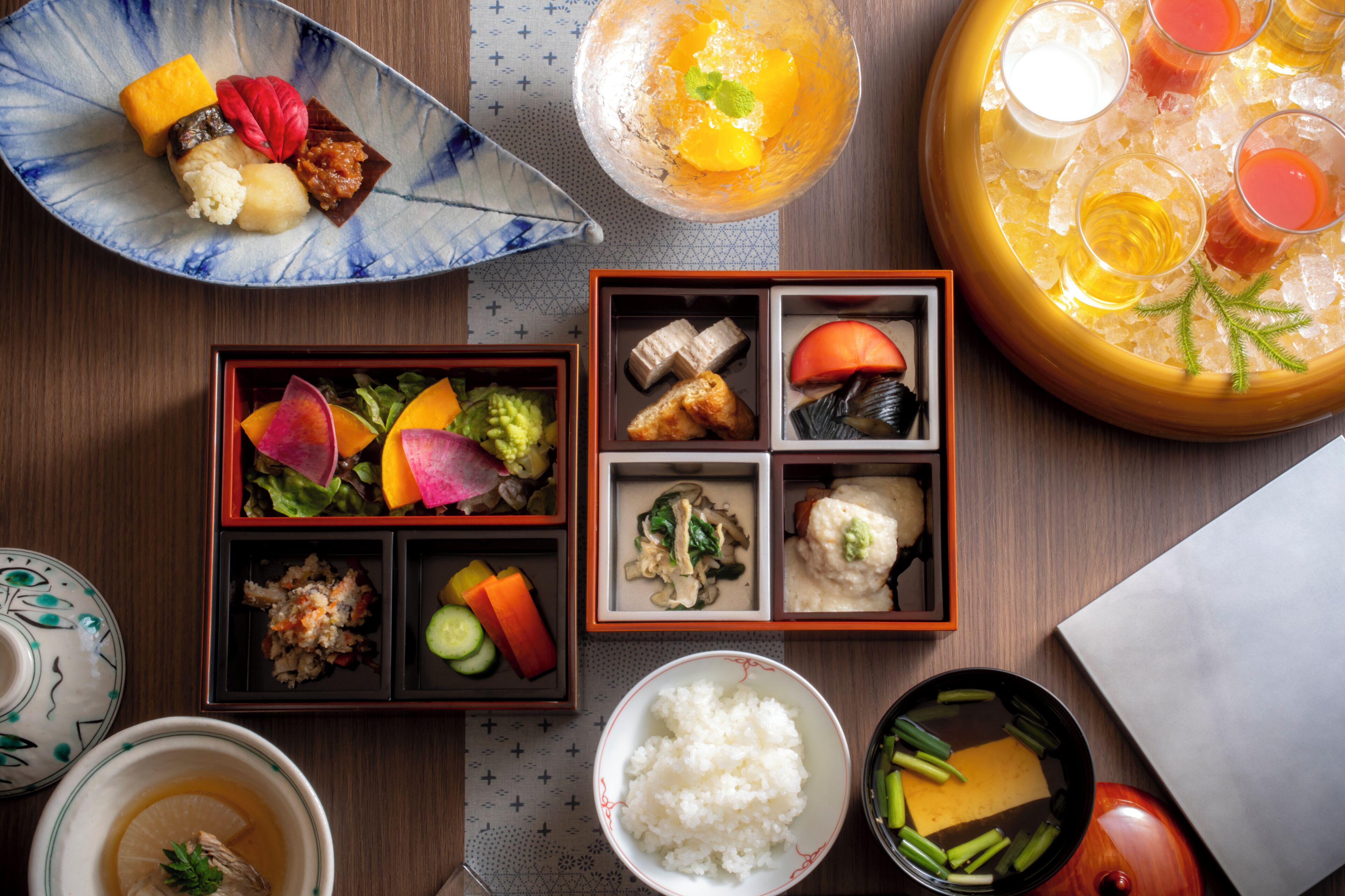 Uma mesa com uma refeição tradicional japonesa, incluindo diversos pratos e bebidas.
