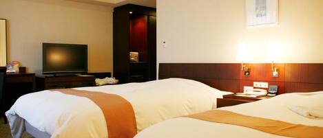 Quarto de hotel com duas camas, televisão, escrivaninha e mesa de cabeceira.