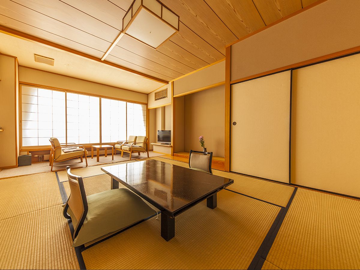 Um quarto japonês tradicional com piso de tatame, uma mesa baixa e portas corrediças.