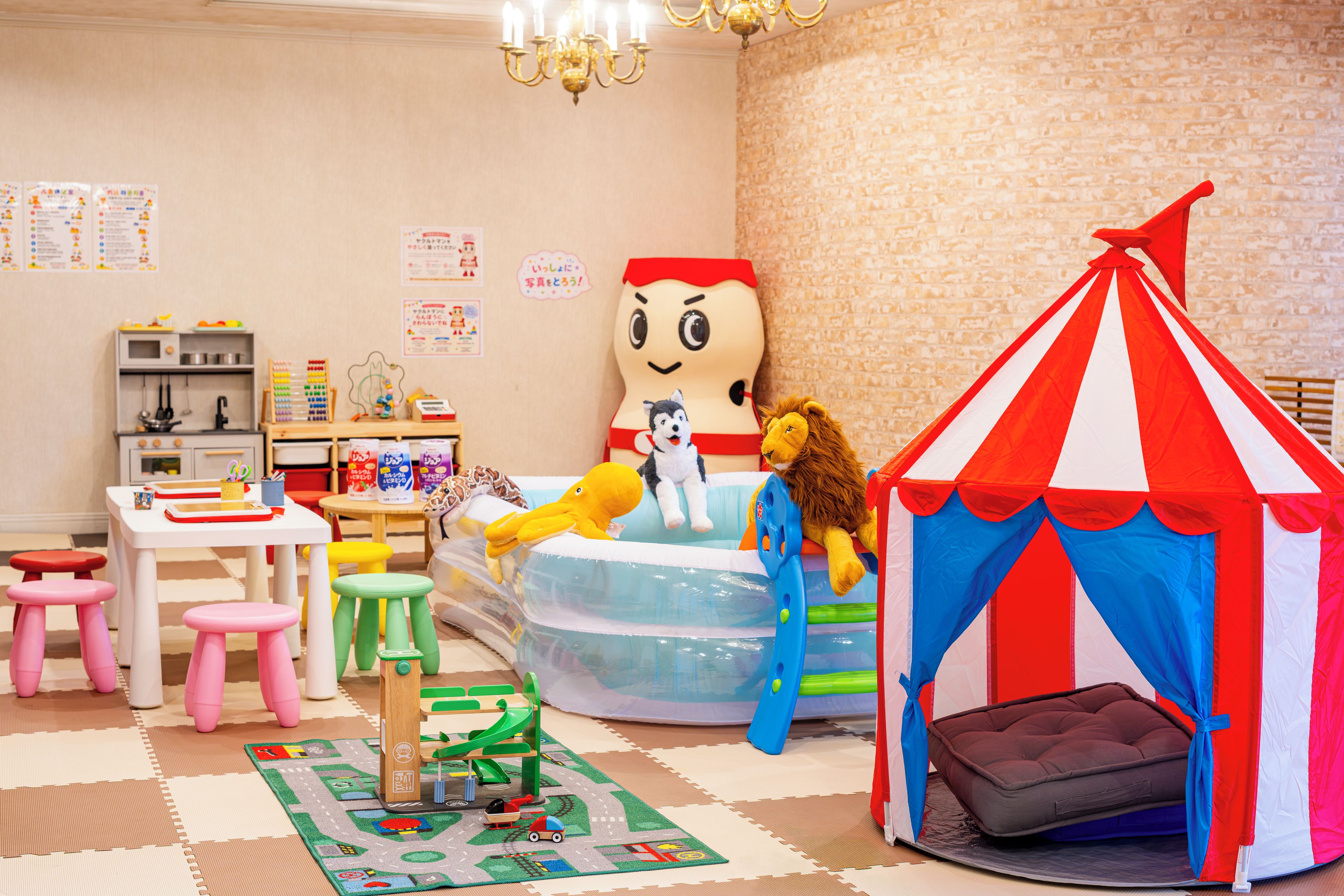 Um espaço de brincadeiras infantil com um escorrega inflável grande, uma tenda e vários brinquedos.