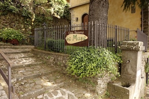 Uma escadaria de pedra leva a um edifício com uma placa que diz 'Casa Vacanze Le Muse'.