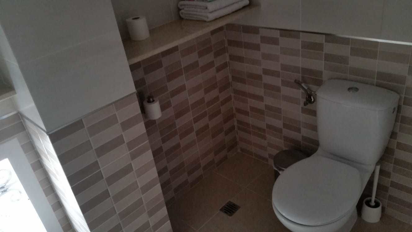Casa de banho com sanita, bidé e um porta-toalhas.