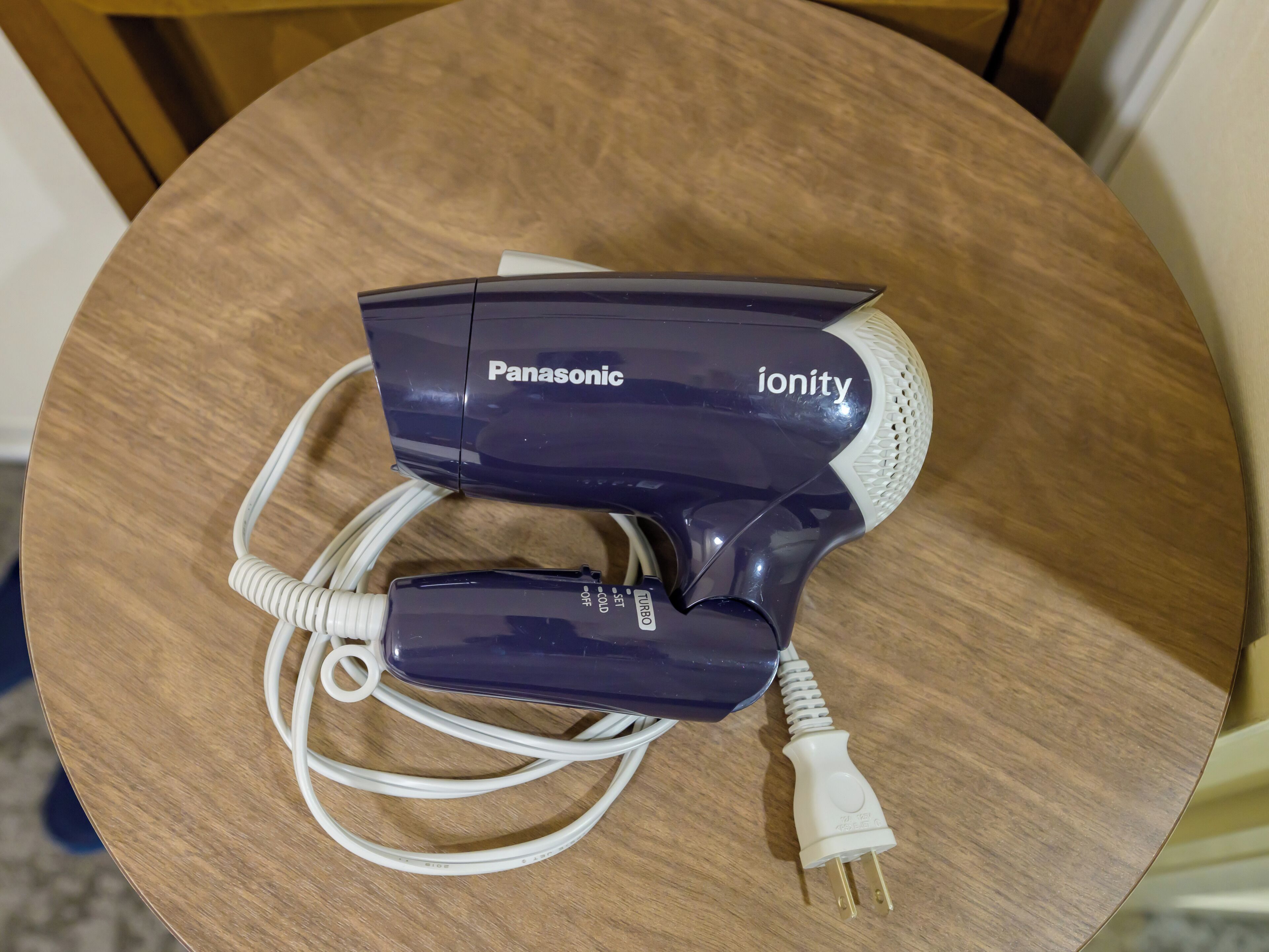Um secador de cabelo Panasonic ionity sobre uma mesa de madeira.