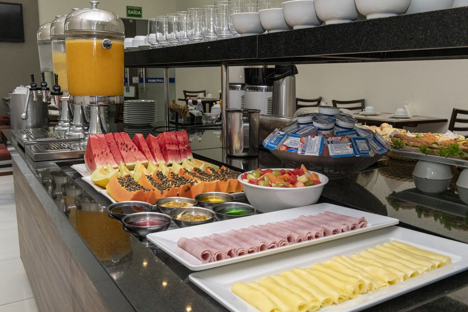 Buffet com diversos alimentos, incluindo frutas, legumes e carnes.