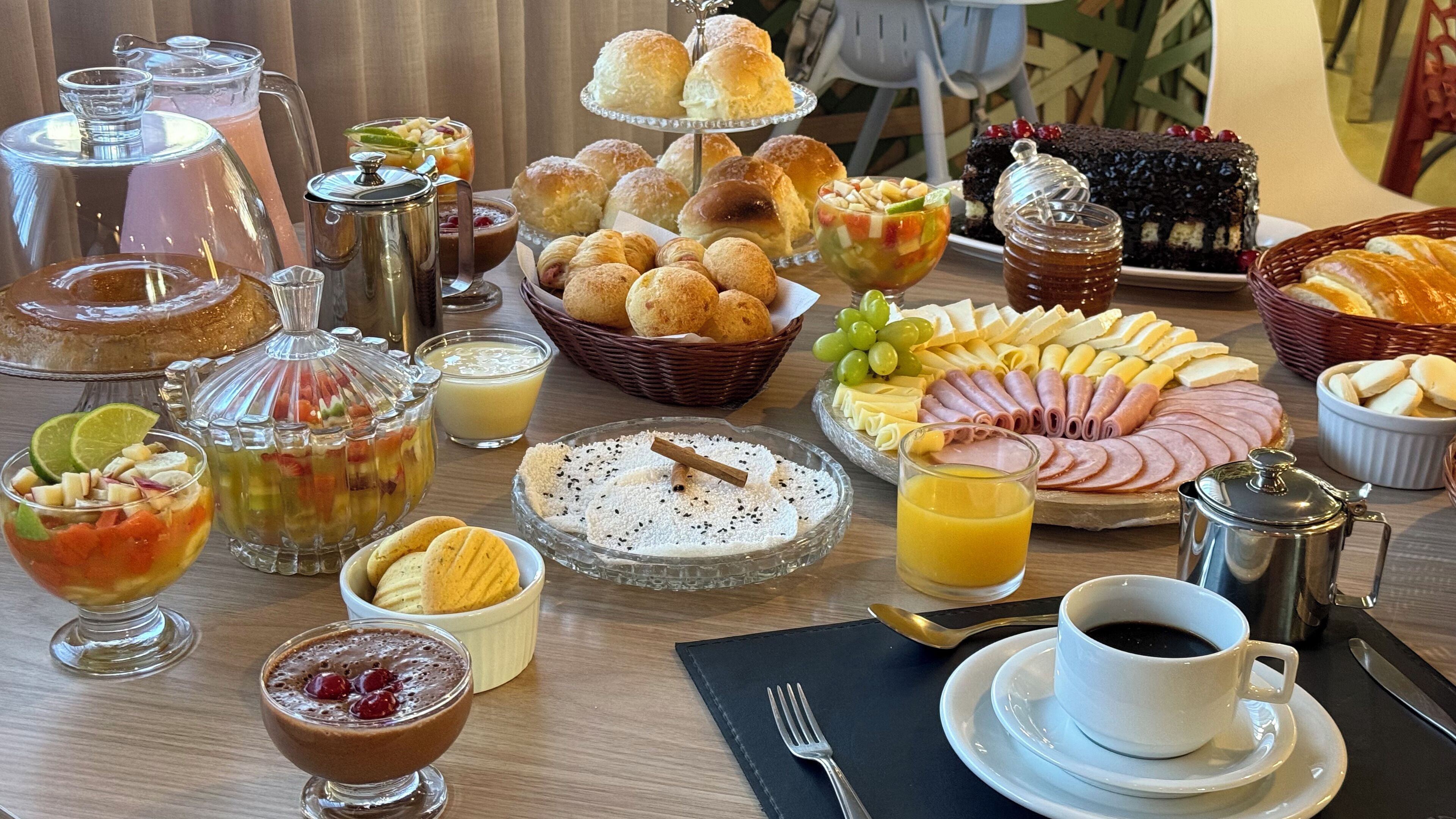 Um buffet de café da manhã com diversas opções de alimentos e bebidas.