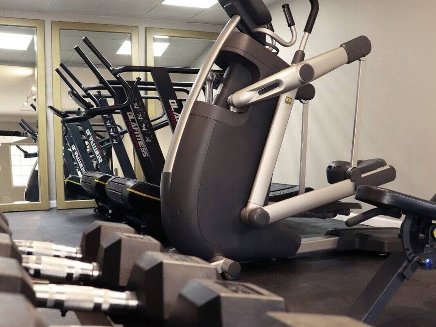Uma academia com equipamentos de exercícios, incluindo esteiras e halteres.