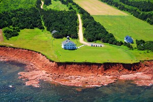 Uma propriedade costeira com uma casa grande, um caminho de terra e uma área gramada.