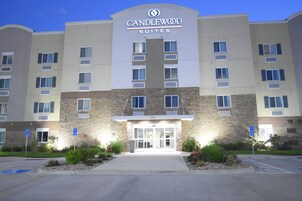 Um hotel com fachada de pedra, várias janelas e uma placa indicando ser Candlewood Suites.