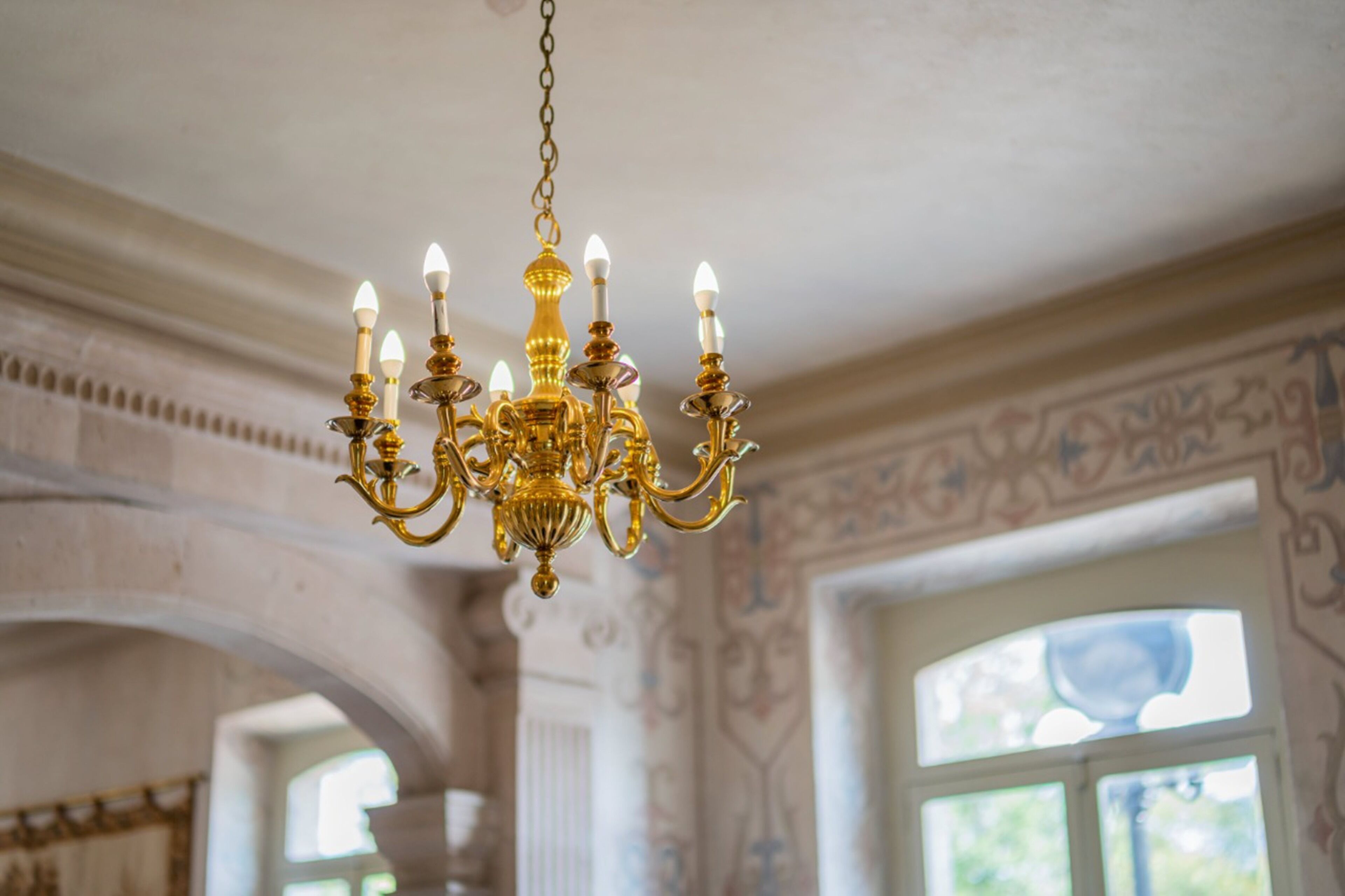 Um candelabro com várias luzes semelhantes a velas penduradas por uma corrente.