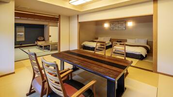 Um quarto em estilo japonês tradicional com tatames, uma mesa de madeira baixa e duas camas de solteiro.