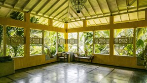 Um quarto amplo, com teto alto, janelas grandes e uma área de estar central.
